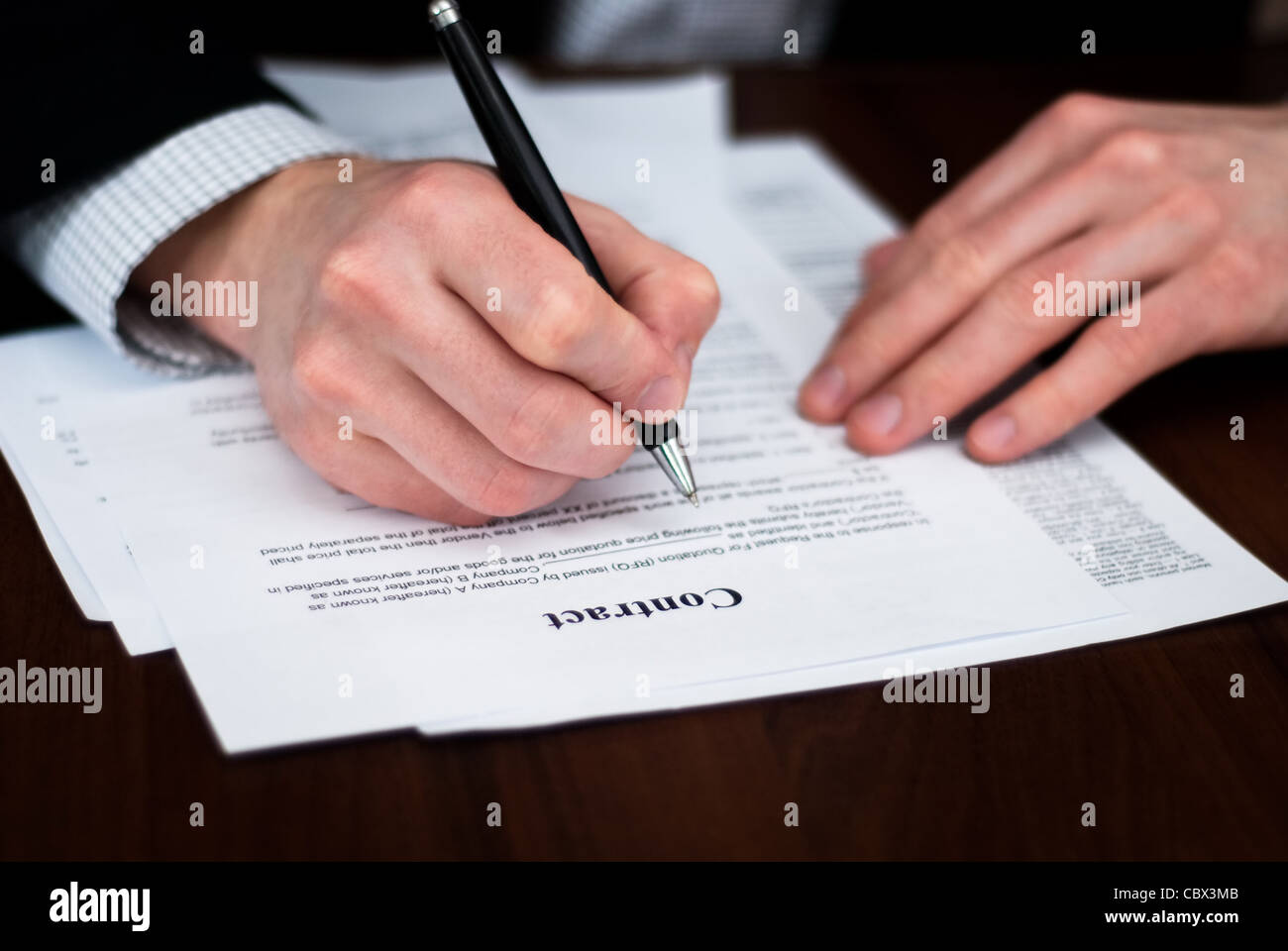 Filling out business documents on a desk Stock Photo - Alamy