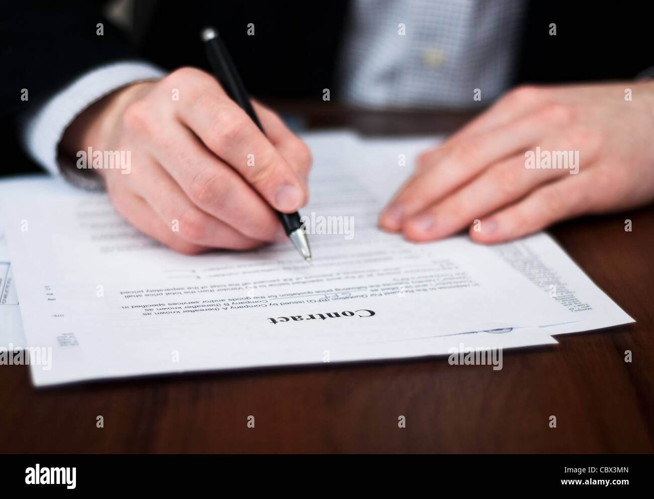 Filling out business documents on a desk Stock Photo - Alamy