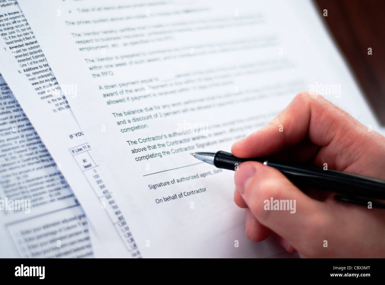 Filling out business documents on a desk Stock Photo - Alamy