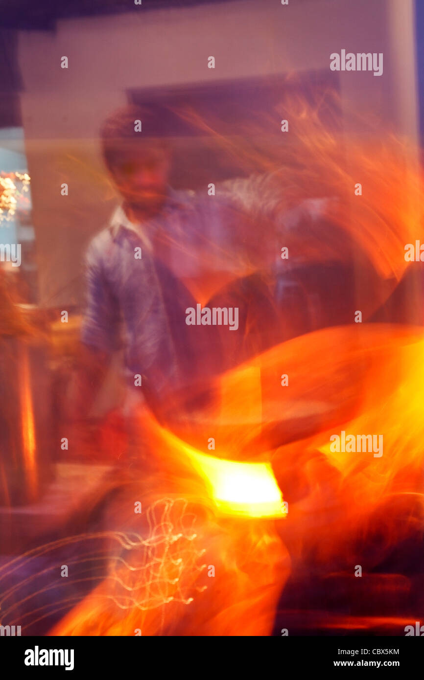 Vertical portrait and motion blur of a cook at Northern Indian roadside ...