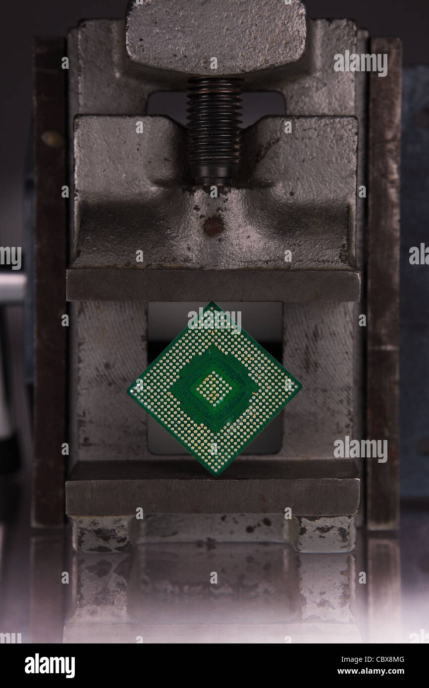 a computer microprocessor between the jaws of a press Stock Photo - Alamy