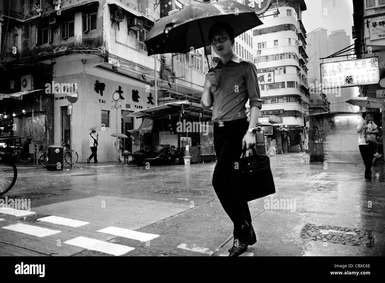 Kowloon, Hong Kong. Man crossing the street during heavy rainfall Stock ...