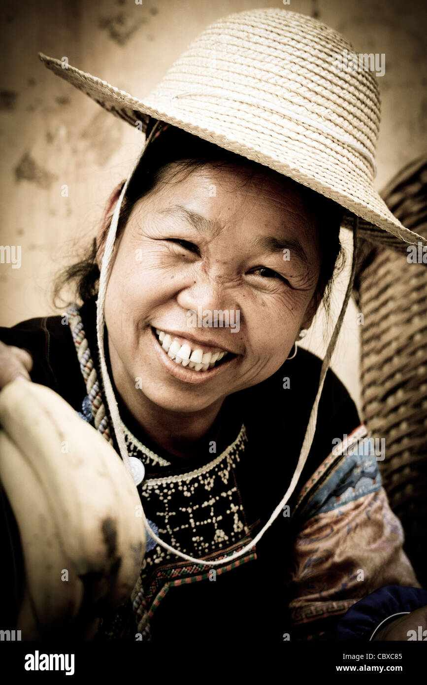 Portrait of a traditional Hani tribeswoman selling fruit at the local ...