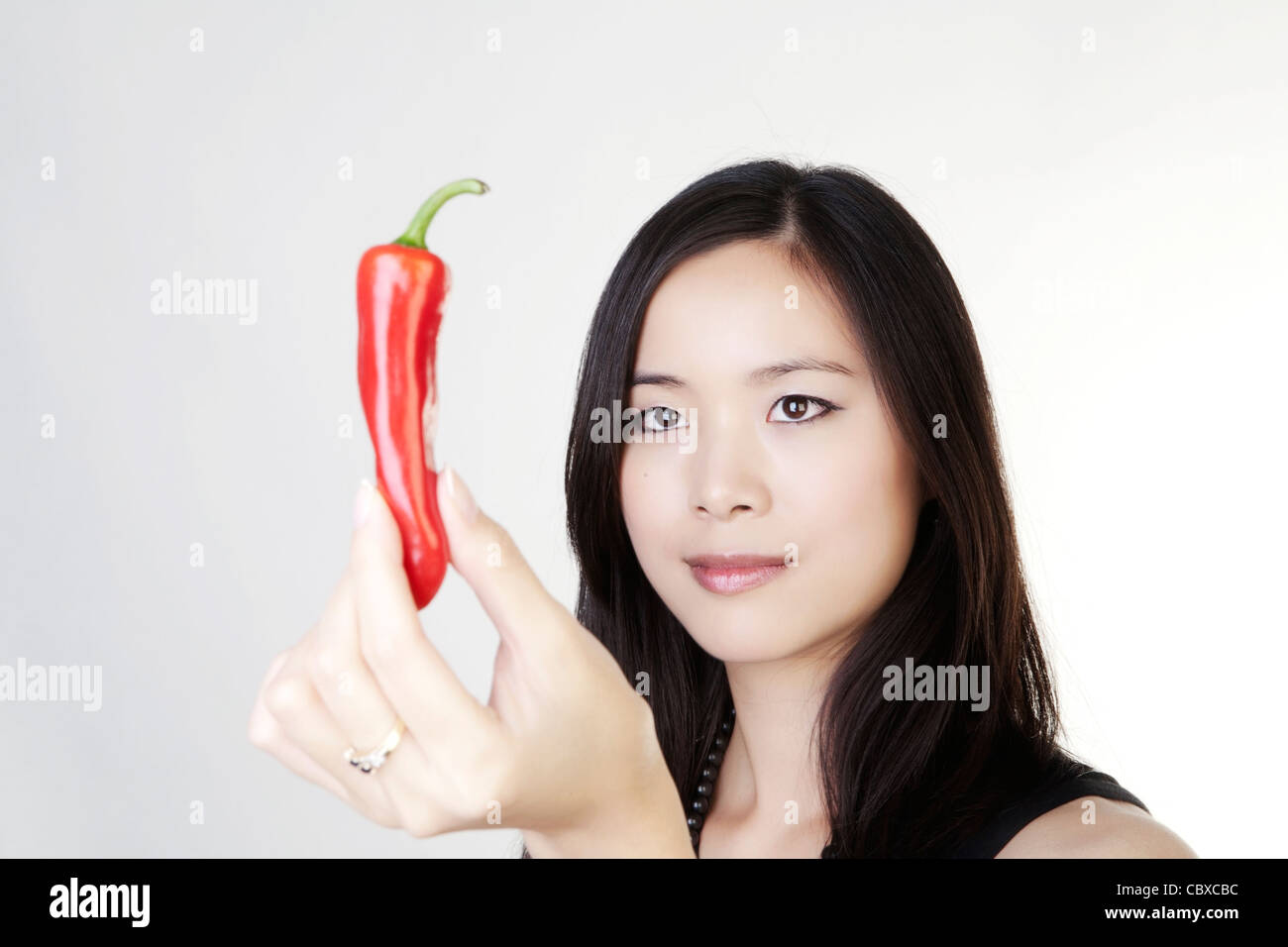 picture of lovely woman with a hot fresh chilli Stock Photo - Alamy