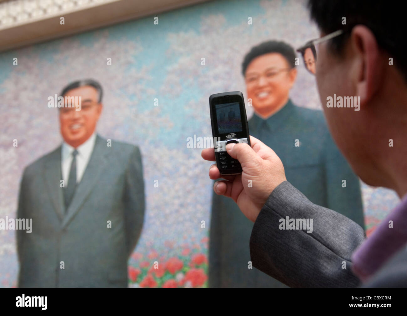 MAN TAKING A PICTURE AT KIMILSUNGIA EXHIBITION, PYONGYANG, NORTH KOREA ...