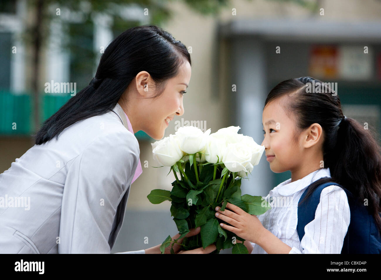 Little girl offering her mother flowers Stock Photo - Alamy
