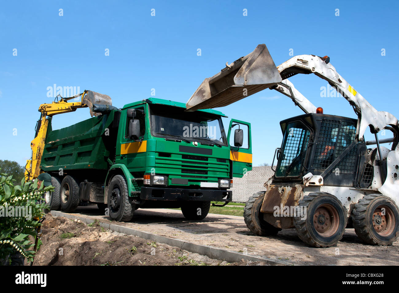 Two excavators loaded dumper at construction site Stock Photo - Alamy