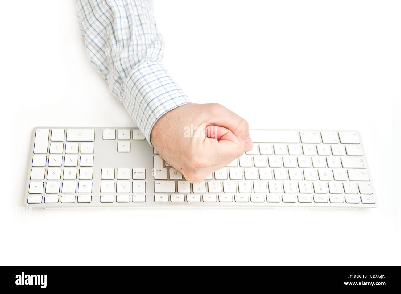 Angry businessman hits the computer keyboard on a white desk top Stock ...