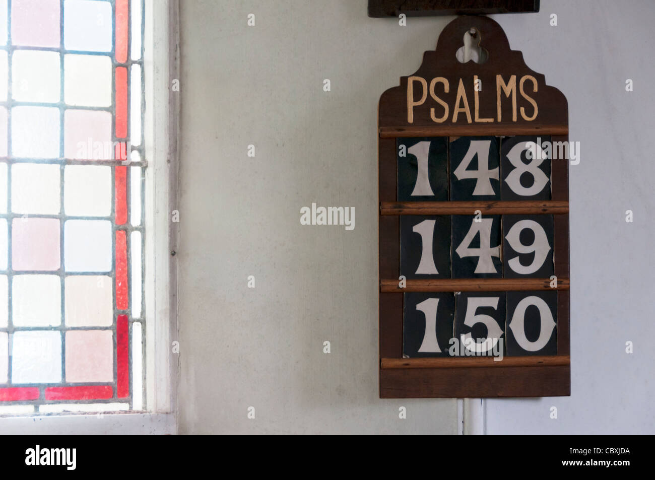 A wooden board with adjustable numbers in a church informs the ...