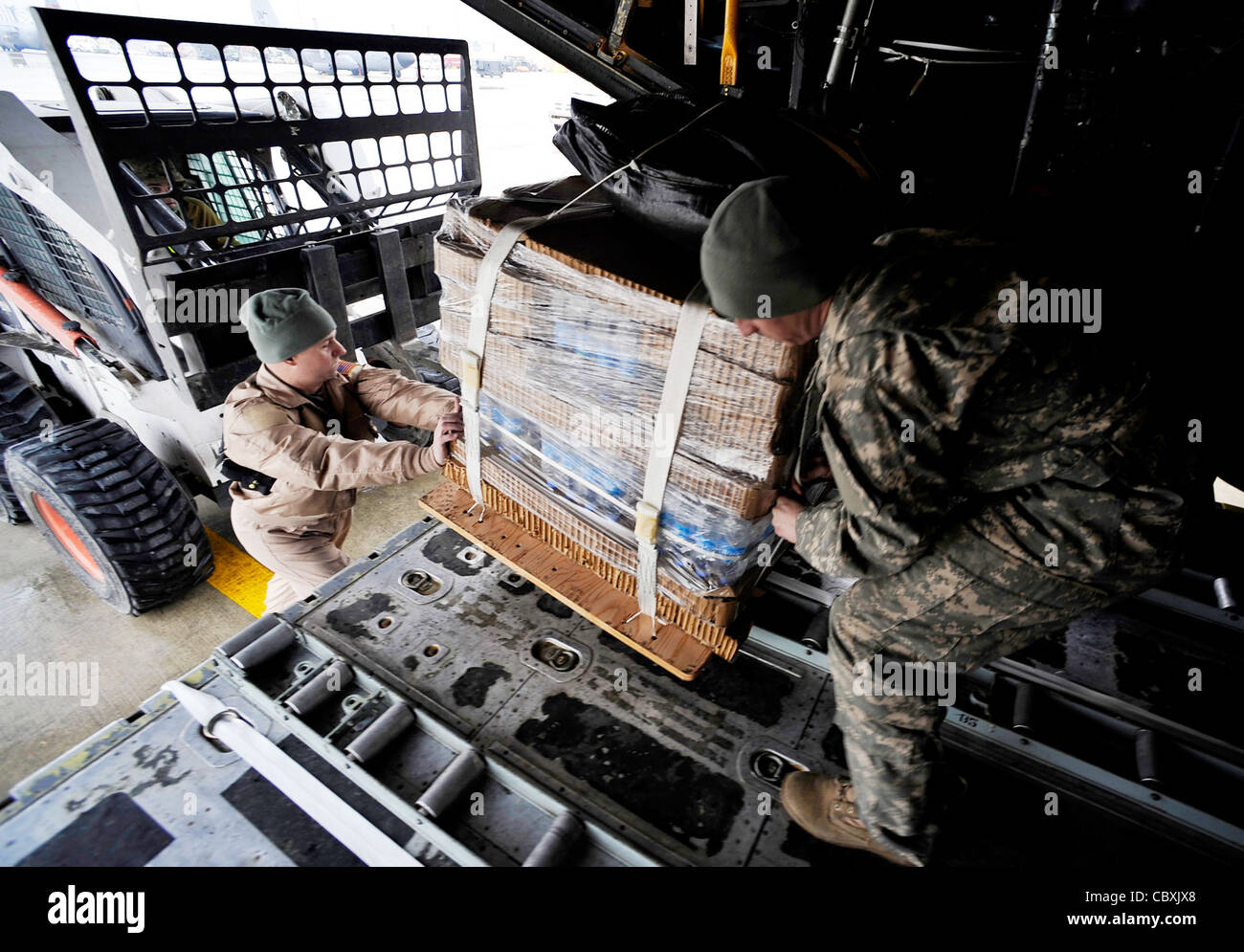 Master Sgt. Clay Holt helps Army Sgt. Matthew Davenport load a C-130 ...