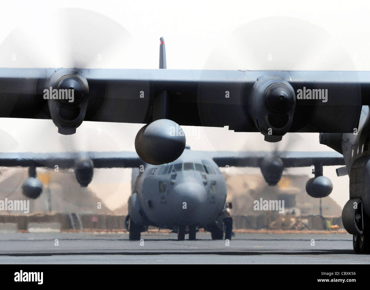 Two C-130 Hercules run engines on the parking ramp before mission ...