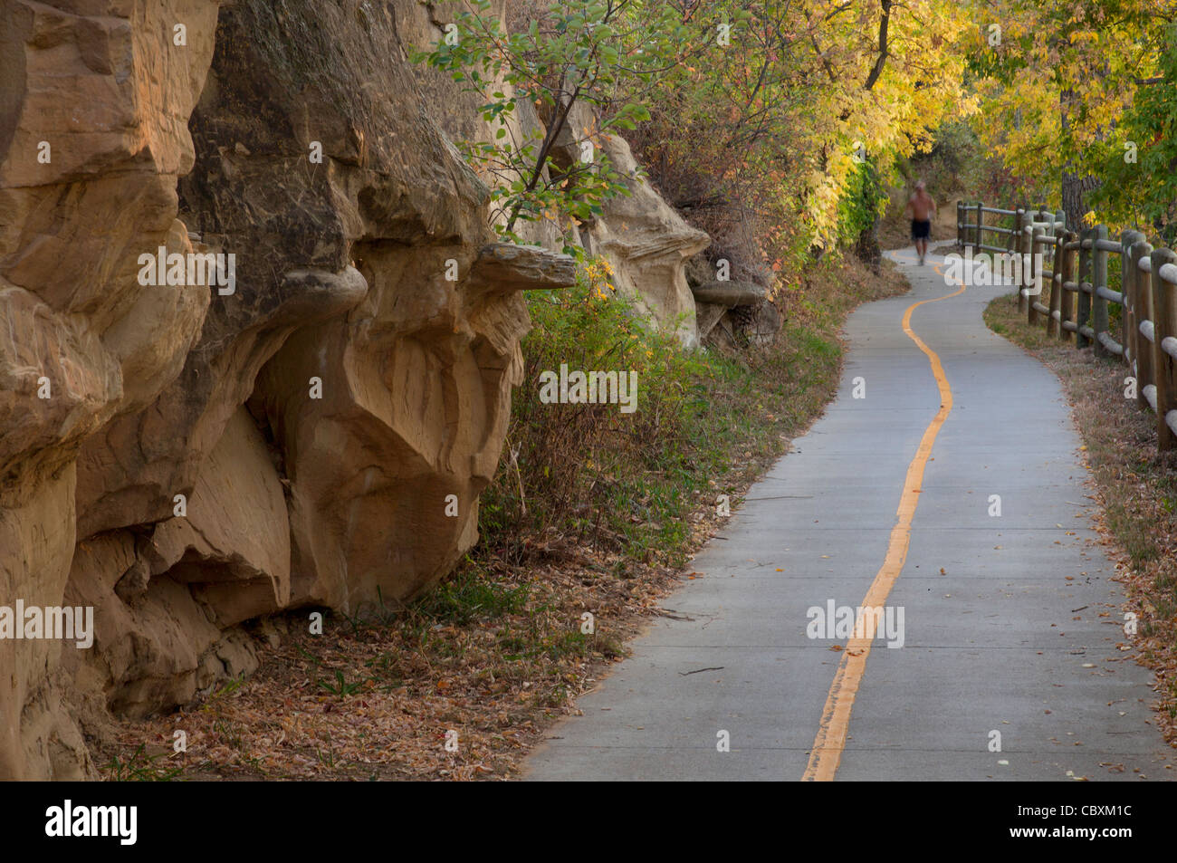 narrow bike path with a blurred runner figure, fall scenery, Poudre ...