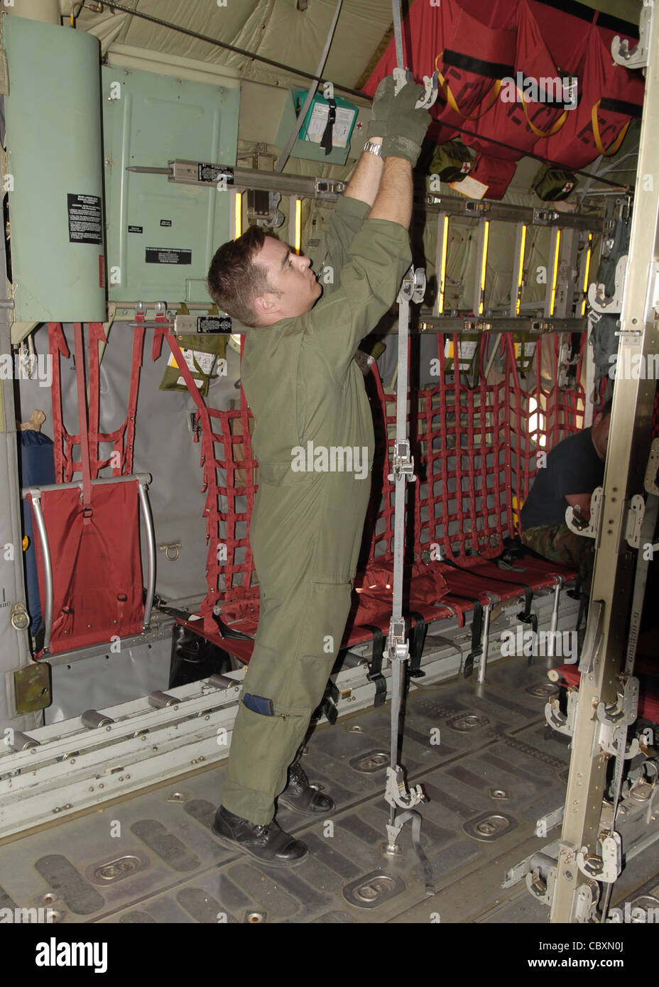 Tech. Sgt. Tom Hough checks litter stanchion straps on a C-130 Hercules ...