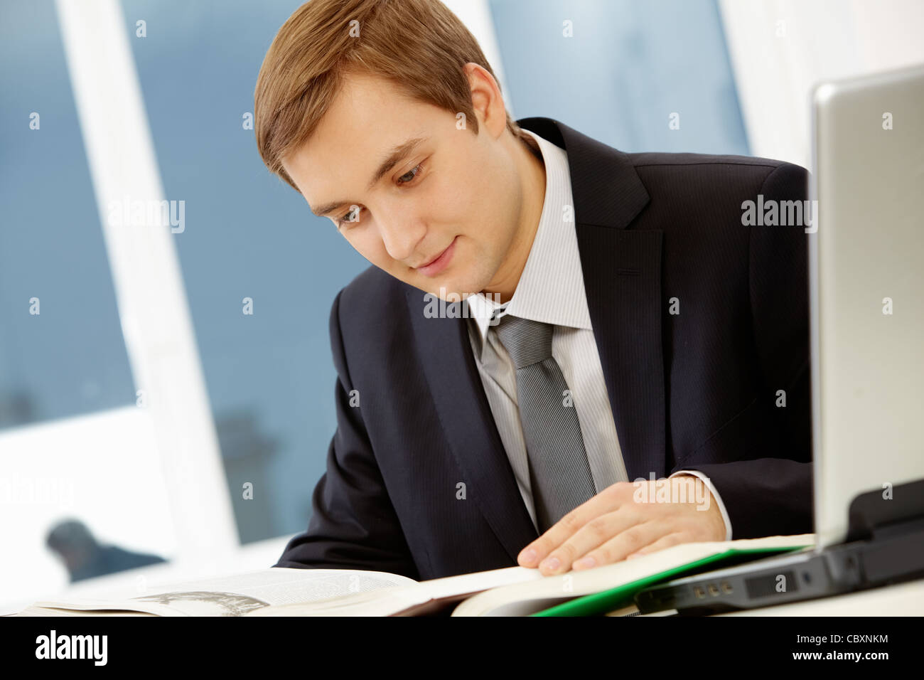 Portrait of thinking businessman reading book Stock Photo - Alamy