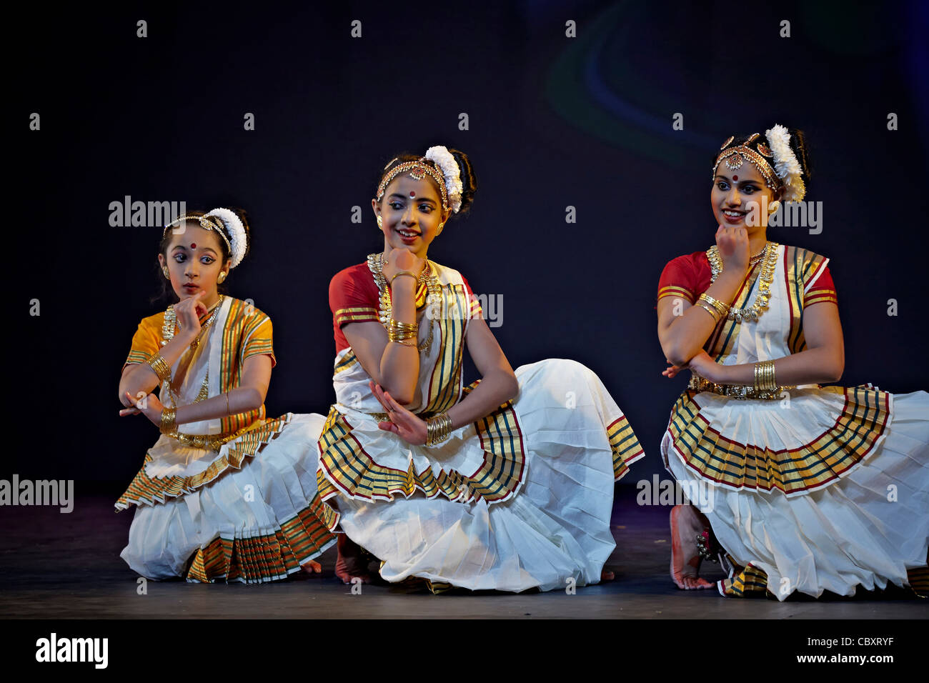 Asian Indian dancers performing on stage wearing traditional costume ...
