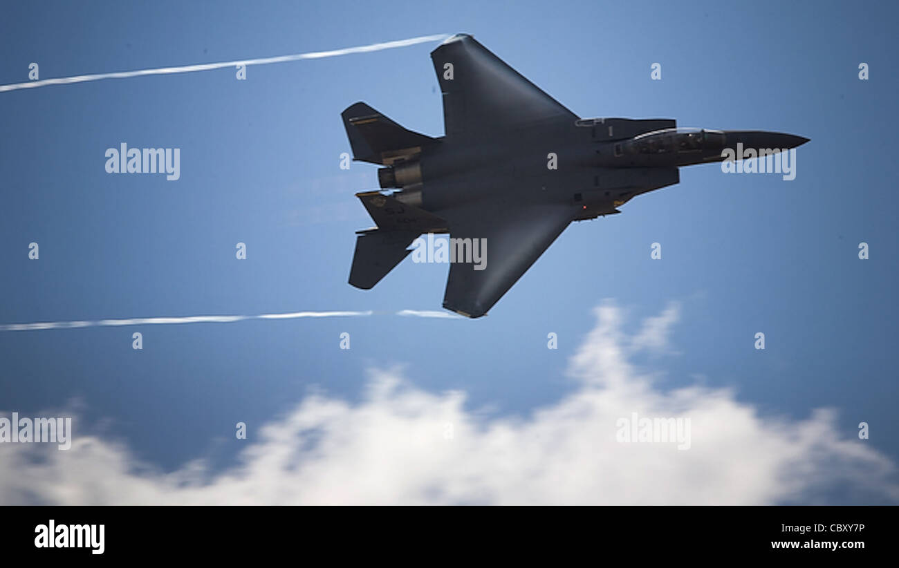 An F-15 Strike Eagle generates vapors on the wing surface during it's ...