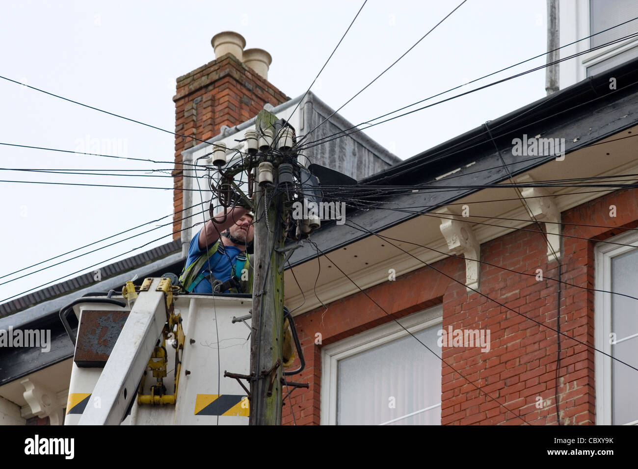 telephone engineer at work replacing old chandelier style telephone ...