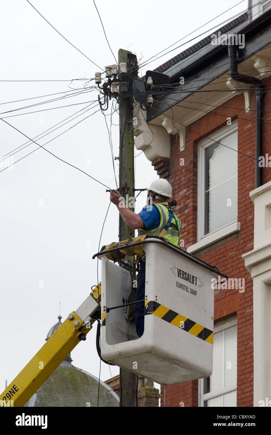 telephone engineer at work replacing old chandelier style telephone ...