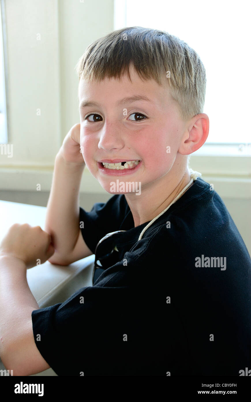 Young boy, who is missing a tooth, smiling at the camera Stock Photo ...