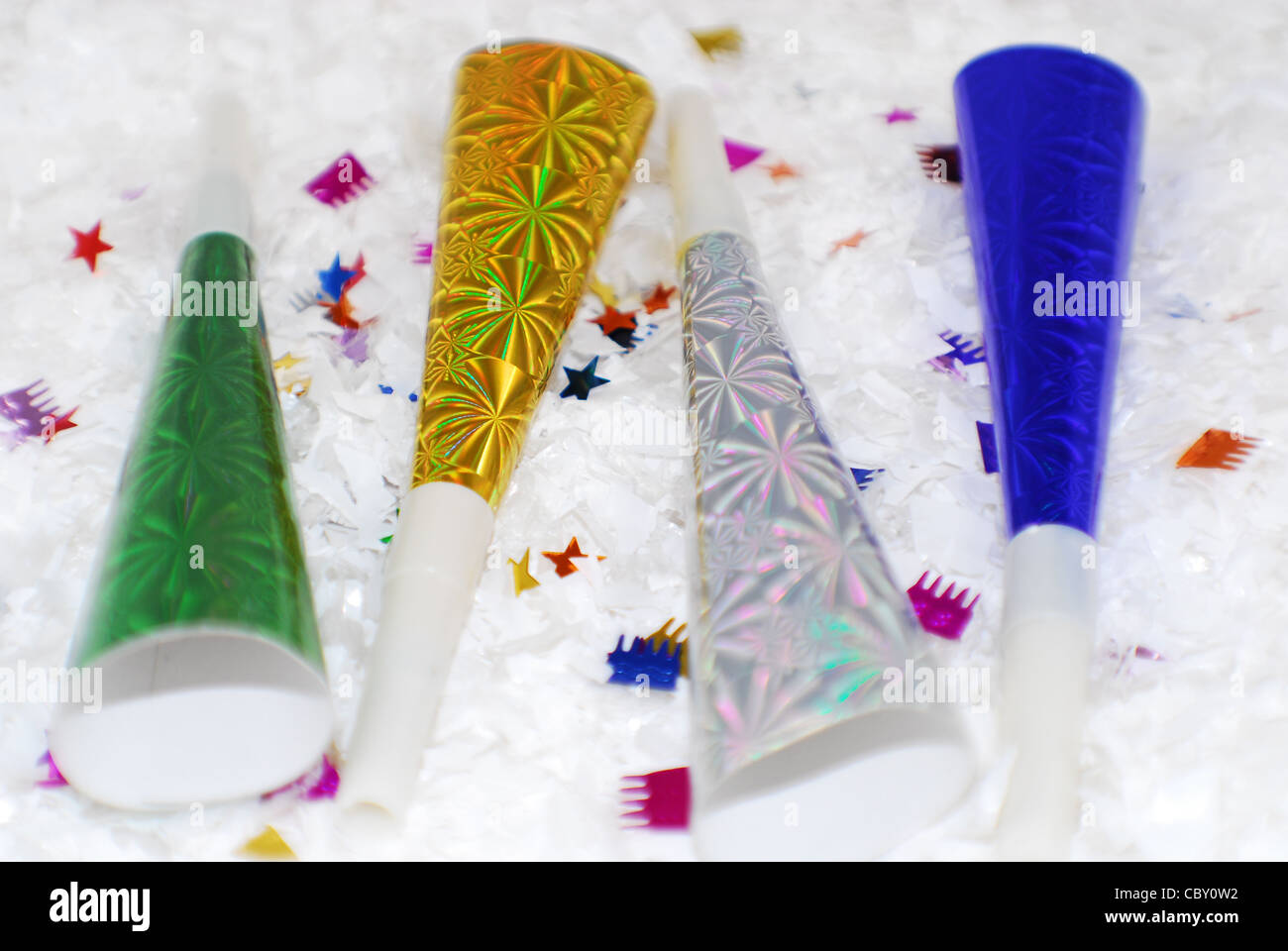 group of colorful holiday horns with confetti on a bed of snow Stock ...