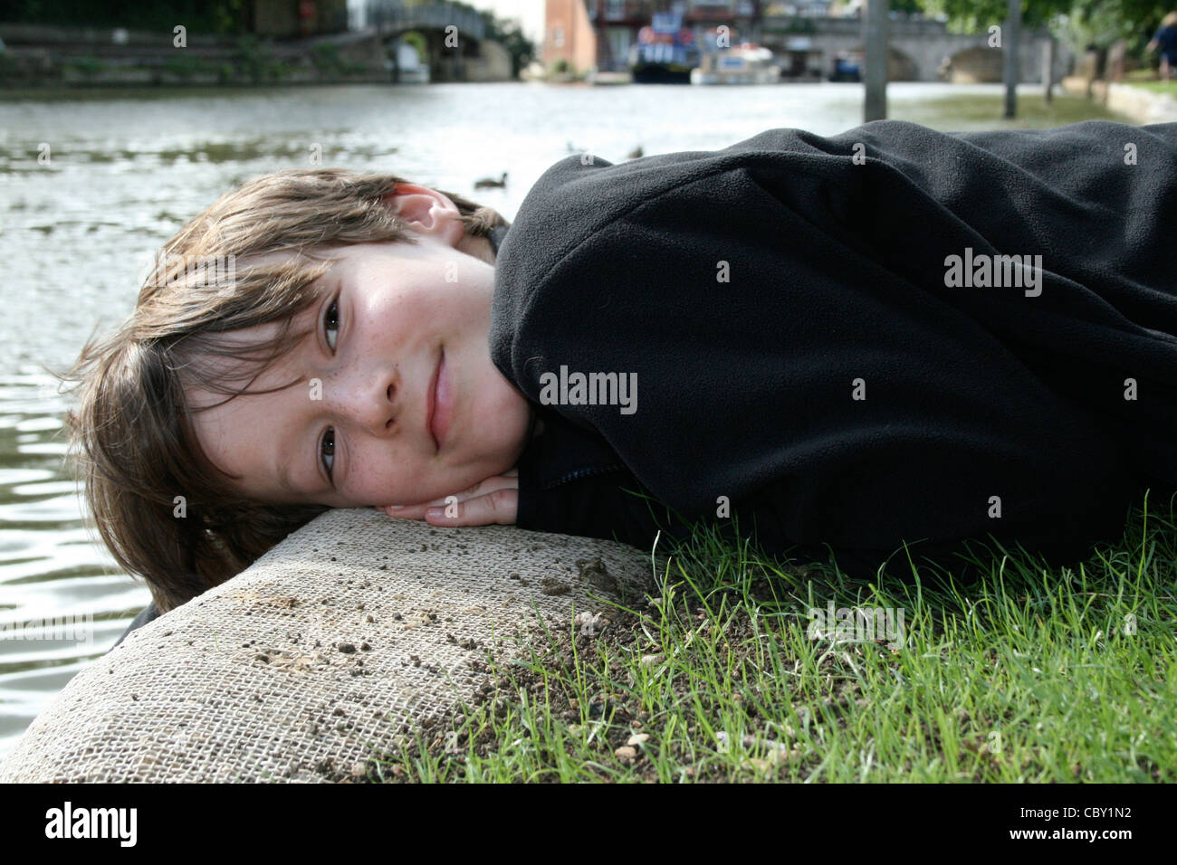 Boy lying on river bank Oxford Stock Photo - Alamy