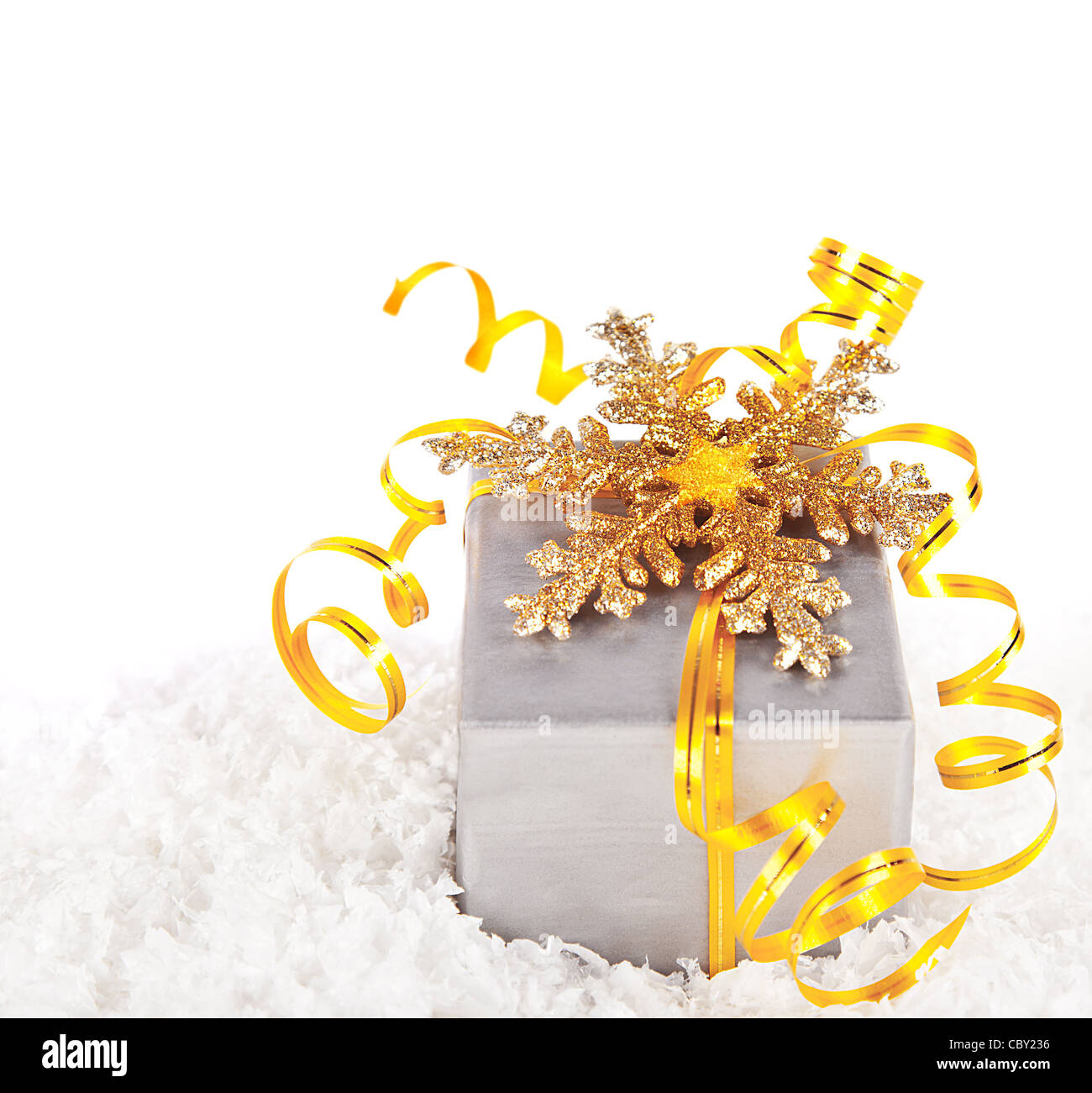 Golden gift with gold ribbons and shiny snowflake, isolated over white ...