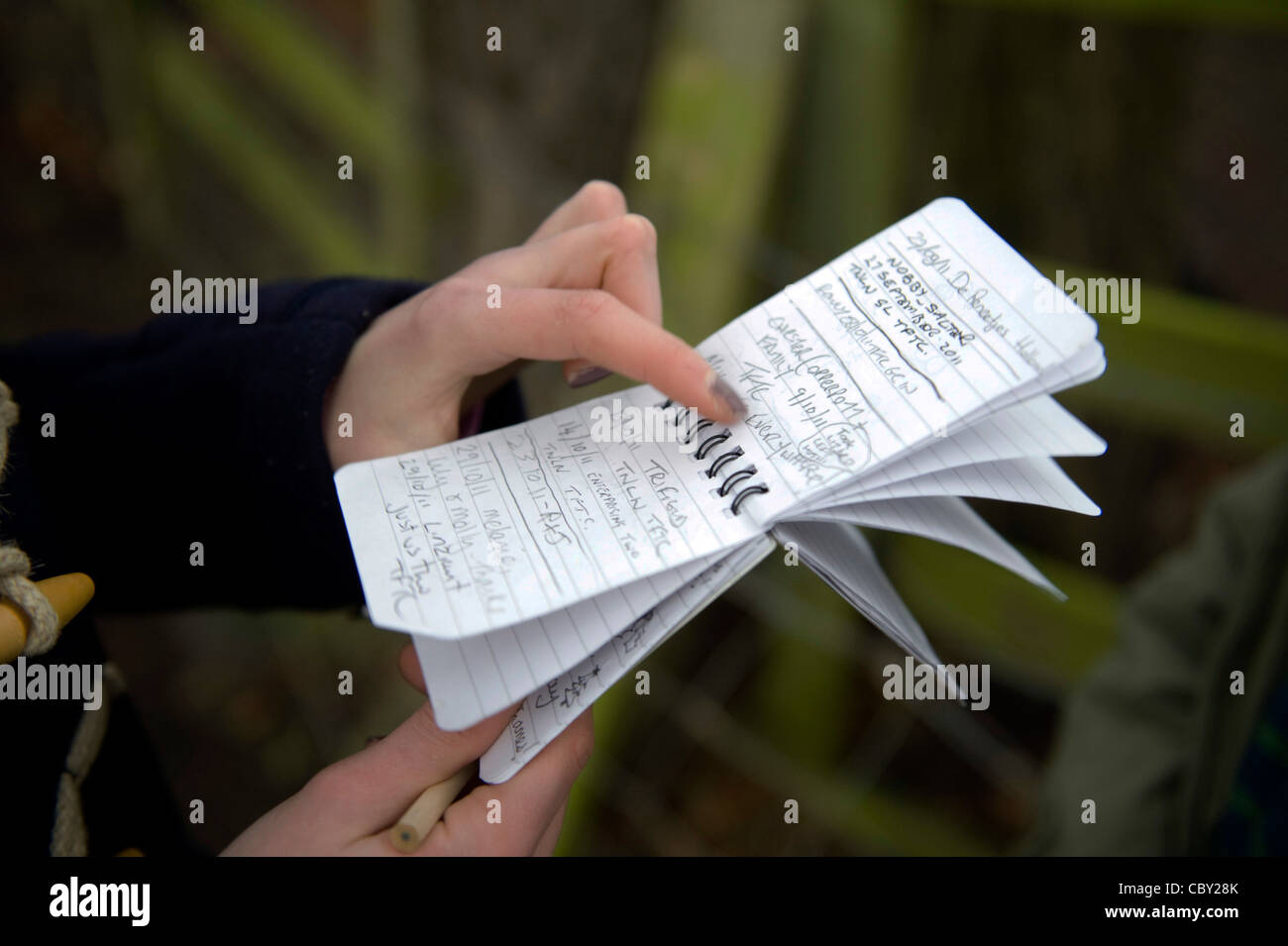 teenage girl writing in a logbook after a geocaching hunt in great ...