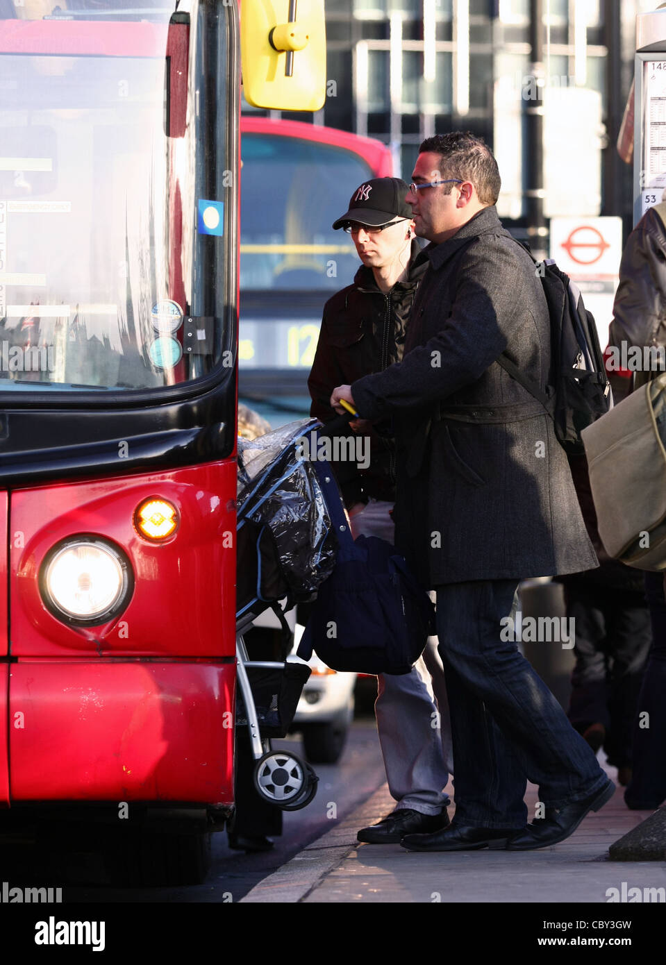 a male boarding a red London bus with a pushchair Stock Photo - Alamy