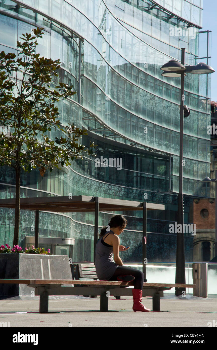 Girl seat in on the bench in Bizkaia square in front of the Basque ...