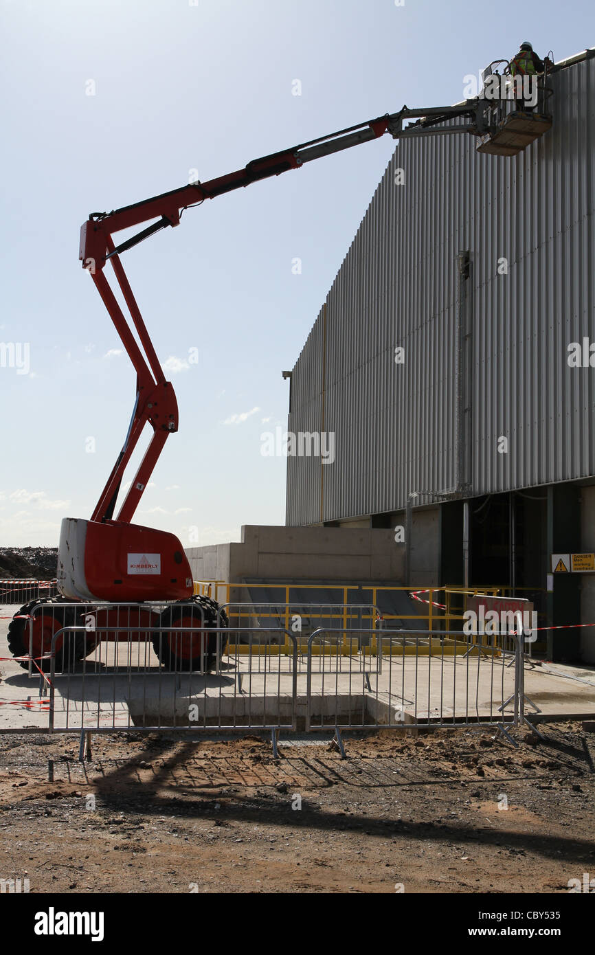 Man working in cherry picker on a new industrial unit Stock Photo - Alamy