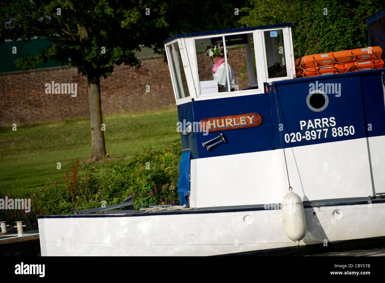 Shuttle Boat Captain on the Thames at Hampton Court wearing flower hat ...