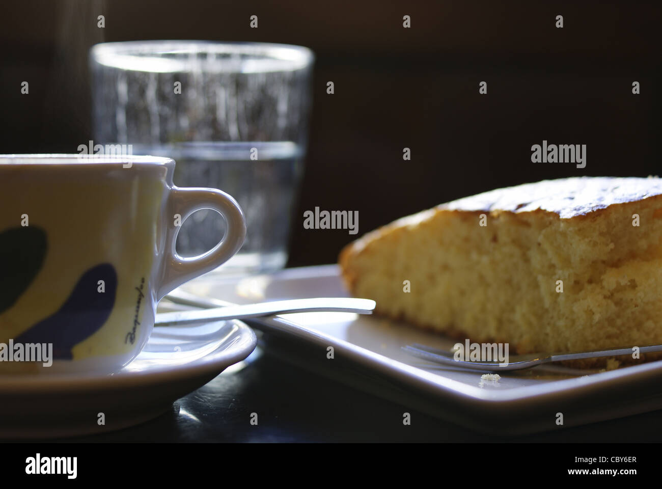 steamy cup of coffee, sponge cake and glass of water Stock Photo - Alamy