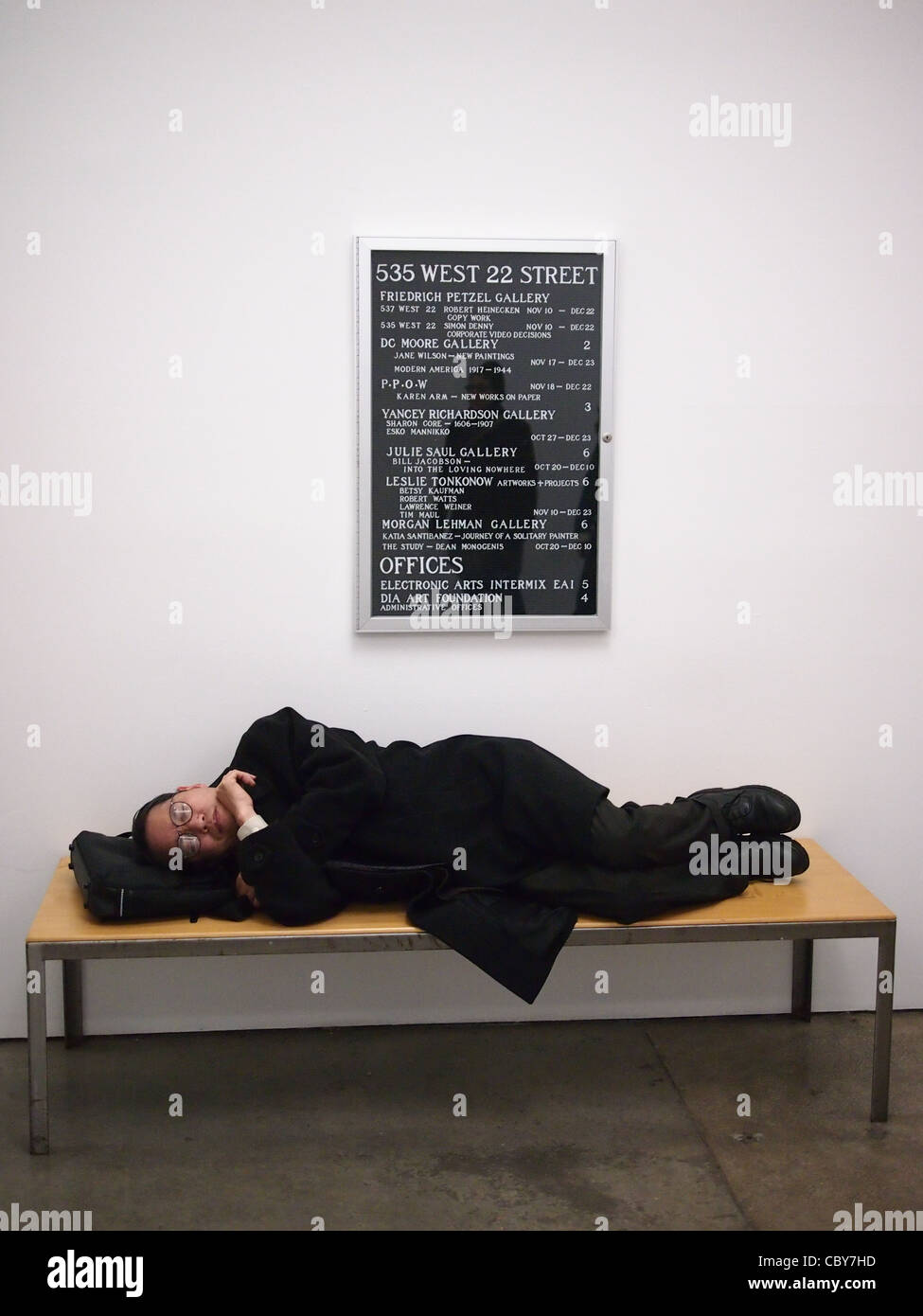 Man sleeping on bench, ground floor of art gallery building, New York ...
