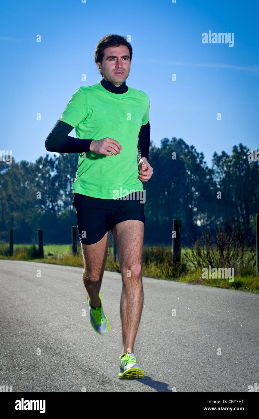 Male runner at sprinting speed training for marathon outdoors on ...