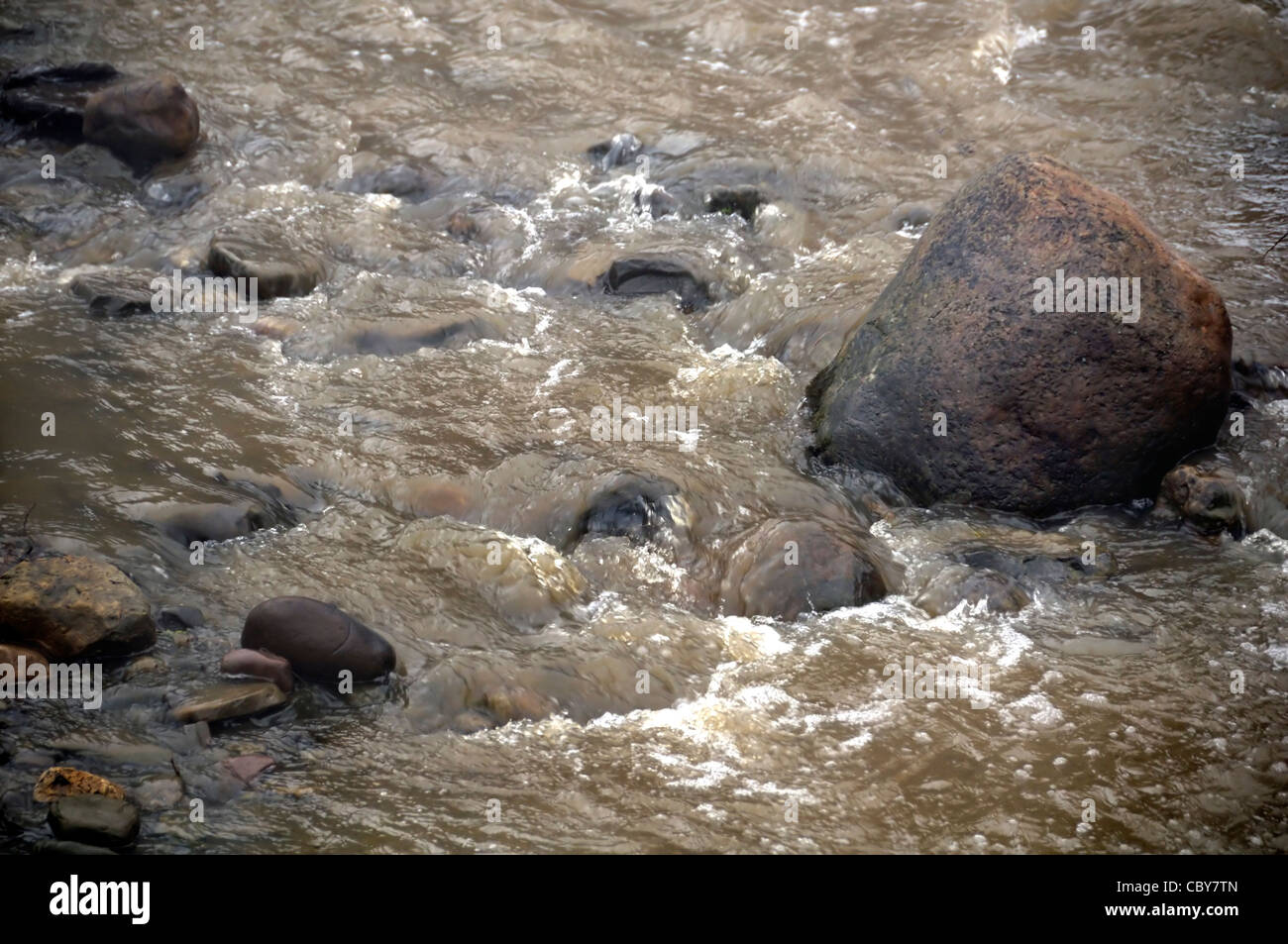 river in flood stage with large rocks or boulders Stock Photo - Alamy