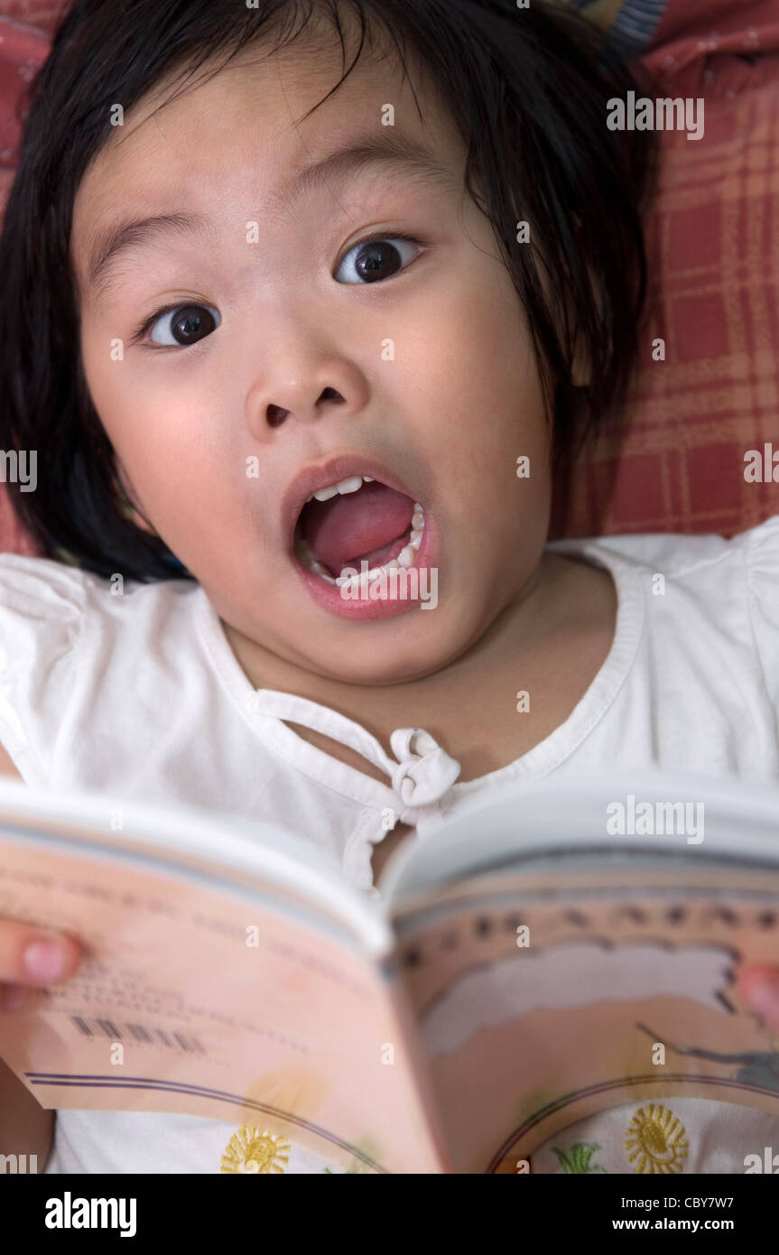 Little girl get shocked in reading Stock Photo - Alamy