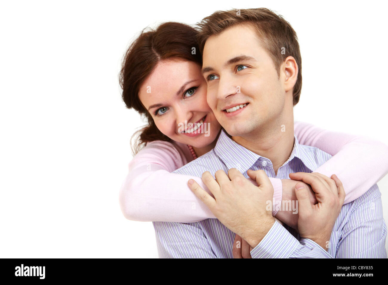 A young girl embracing her boyfriend, looking at camera and both ...