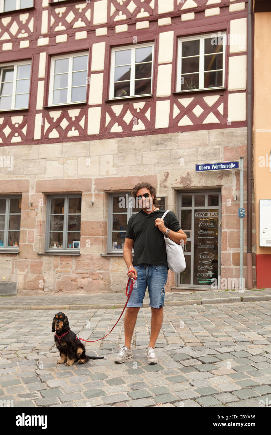 Man with English cocker spaniel in the cobblestoned streets of ...