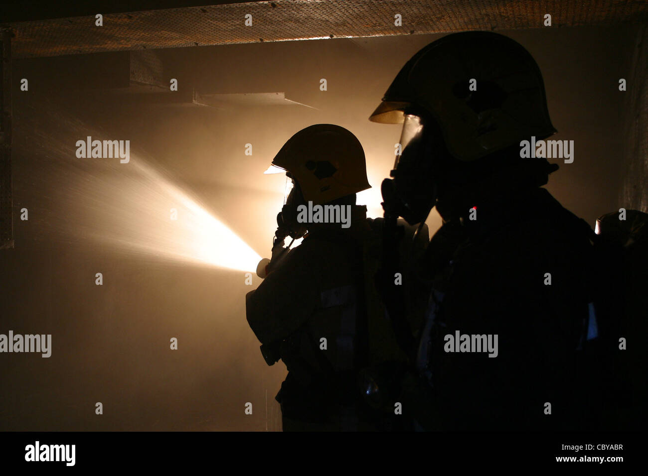 Firefighters wearing breathing apparatus in a smoke filled room Stock ...