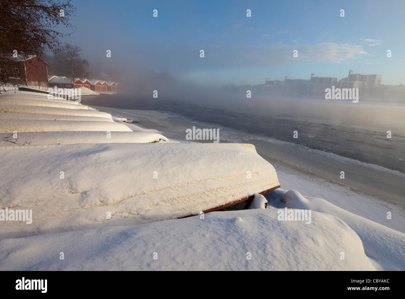 Upturned rowboats / skiffs / dinghies covered with snow at river ...