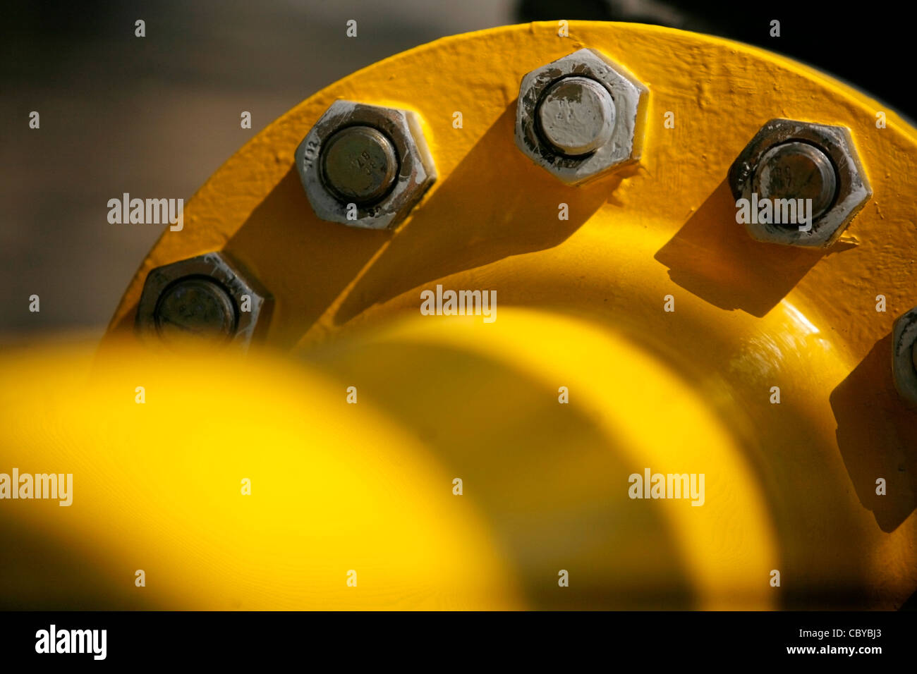 Detail of a yellow pipe with screws Stock Photo - Alamy