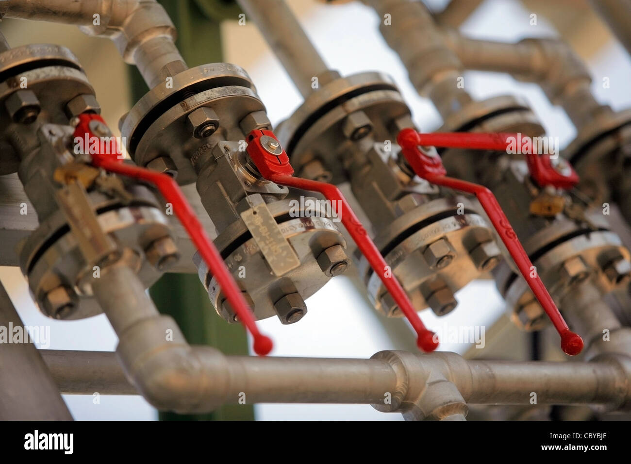 Red levers on industrial pipes in a factory Stock Photo - Alamy