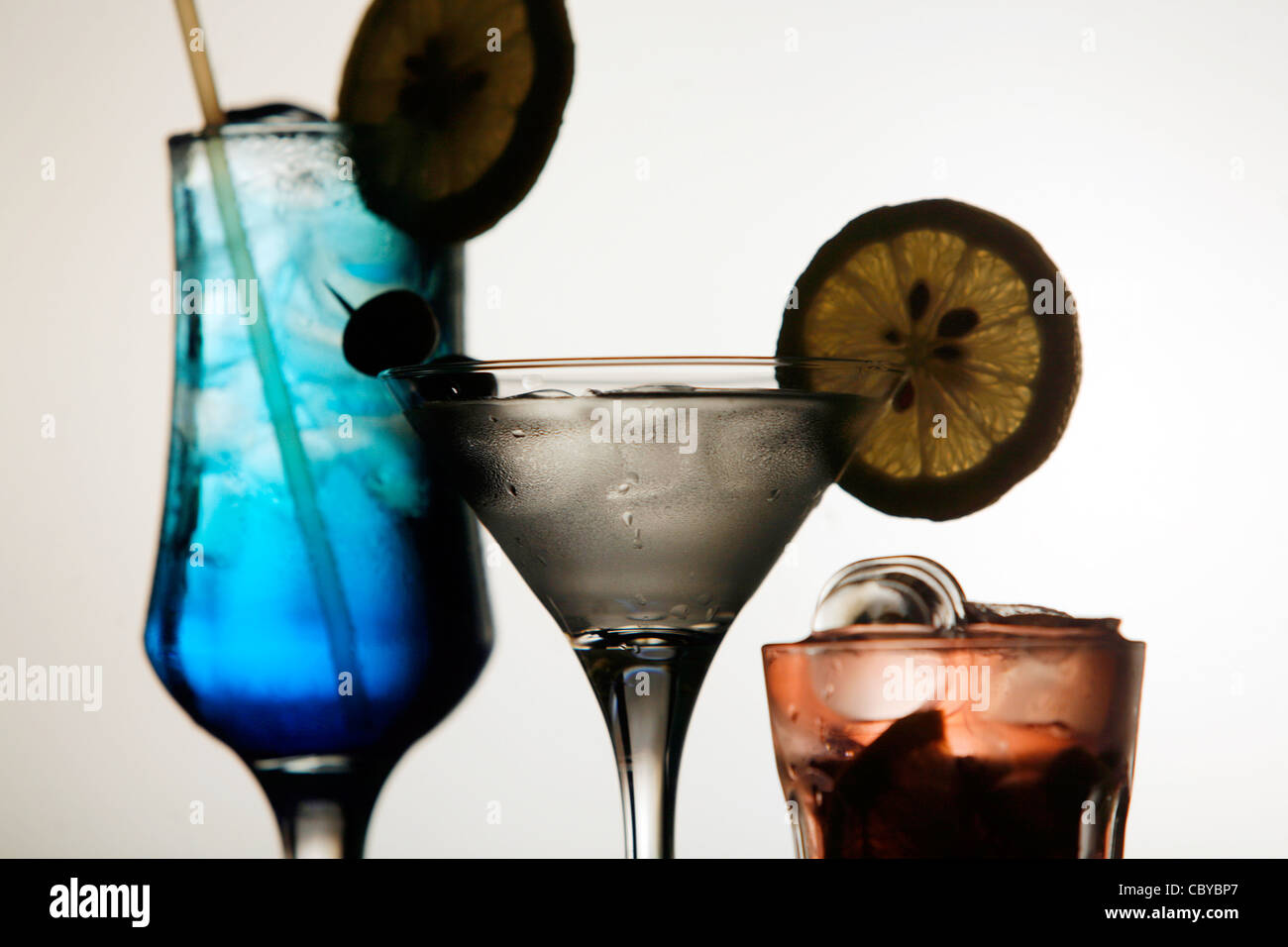 Three cocktails in a row against a light background Stock Photo - Alamy