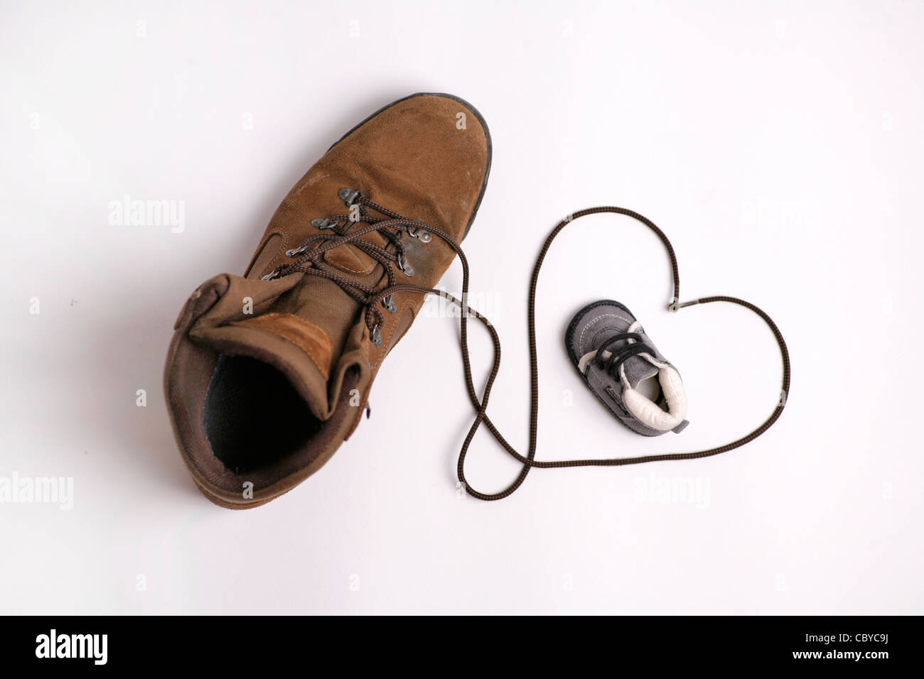 Two shoes, one big, one small, with a heart Stock Photo - Alamy