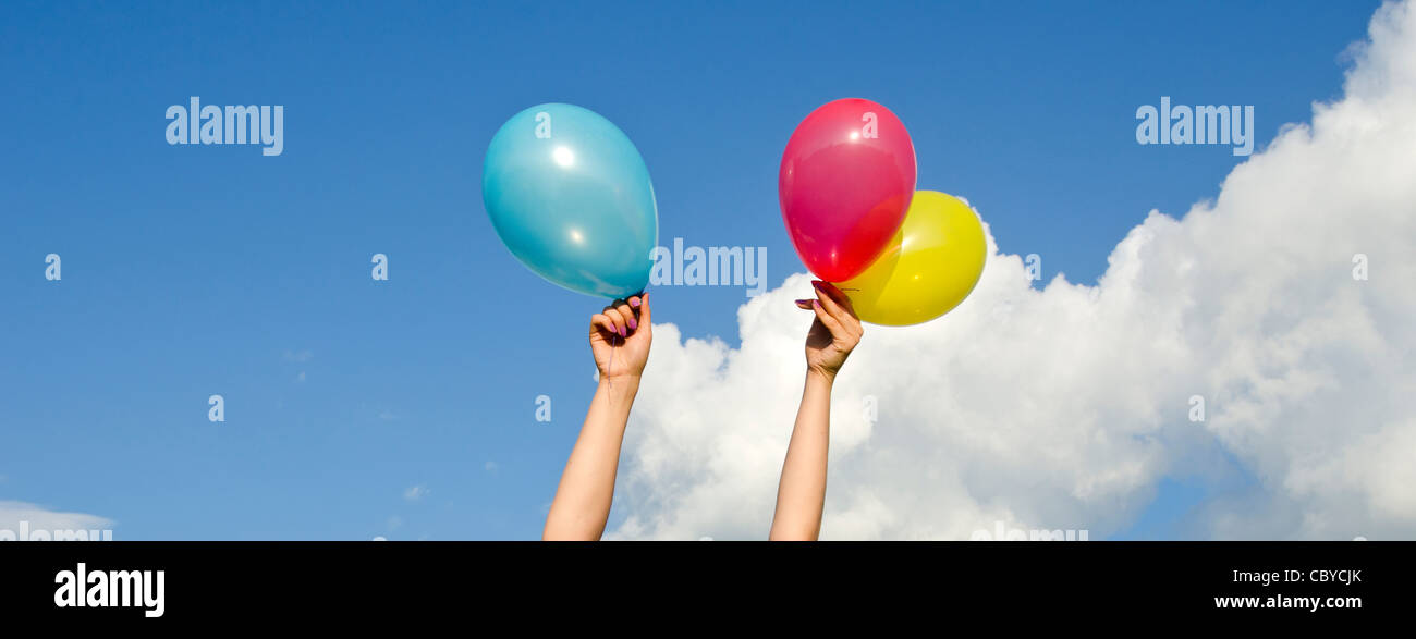 girl hands holding balloons on cloudy sky backgrounds Stock Photo - Alamy