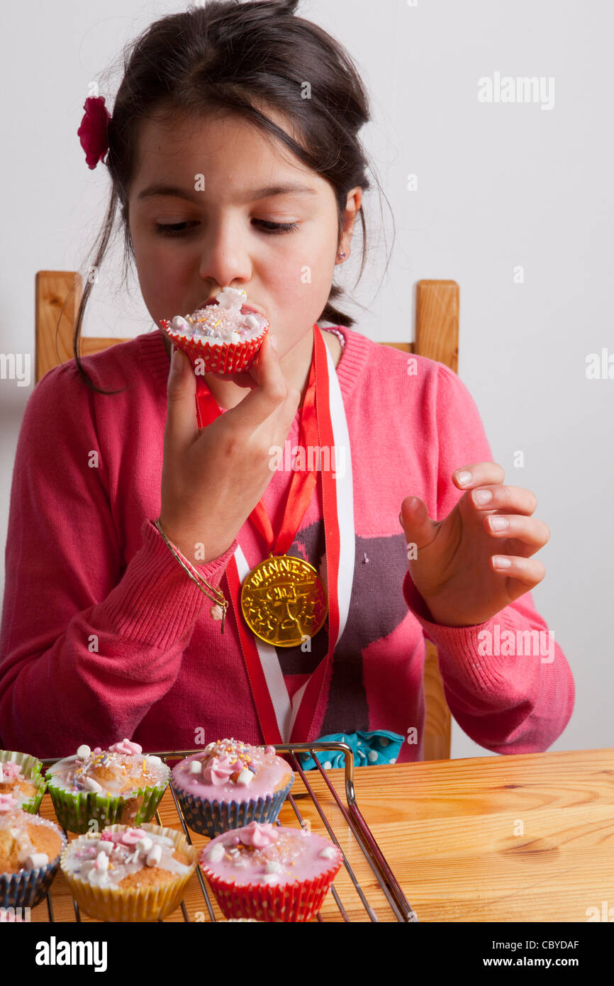 Young girl eating cupcakes alone Stock Photo - Alamy