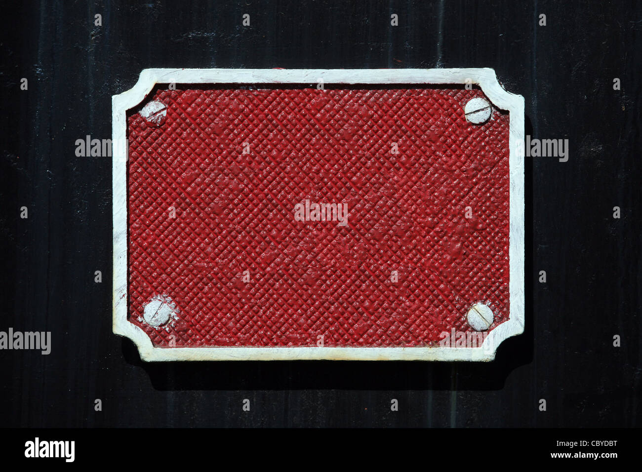 Red metallic board on a black background Stock Photo - Alamy