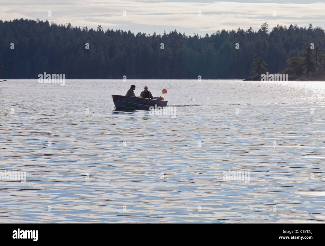Two men out in a small dingy checking their crab traps Stock Photo - Alamy