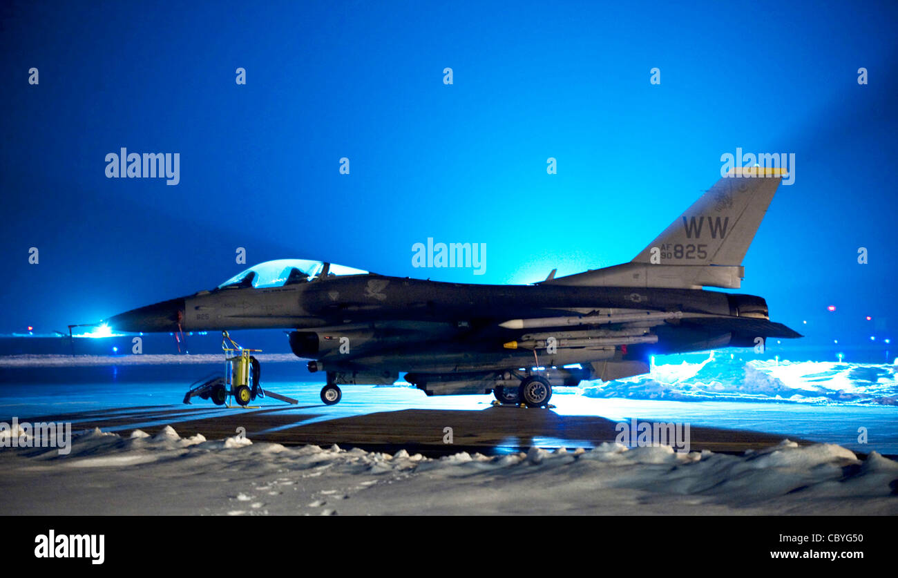 Floodlights illuminate an F-16 Fighting Falcon outside a hardened ...
