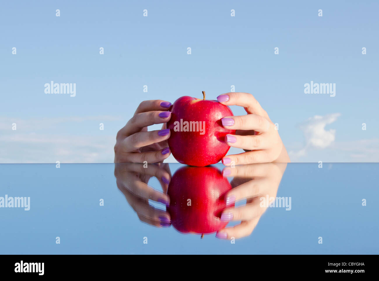 girls hands holding red apple on mirror Stock Photo - Alamy
